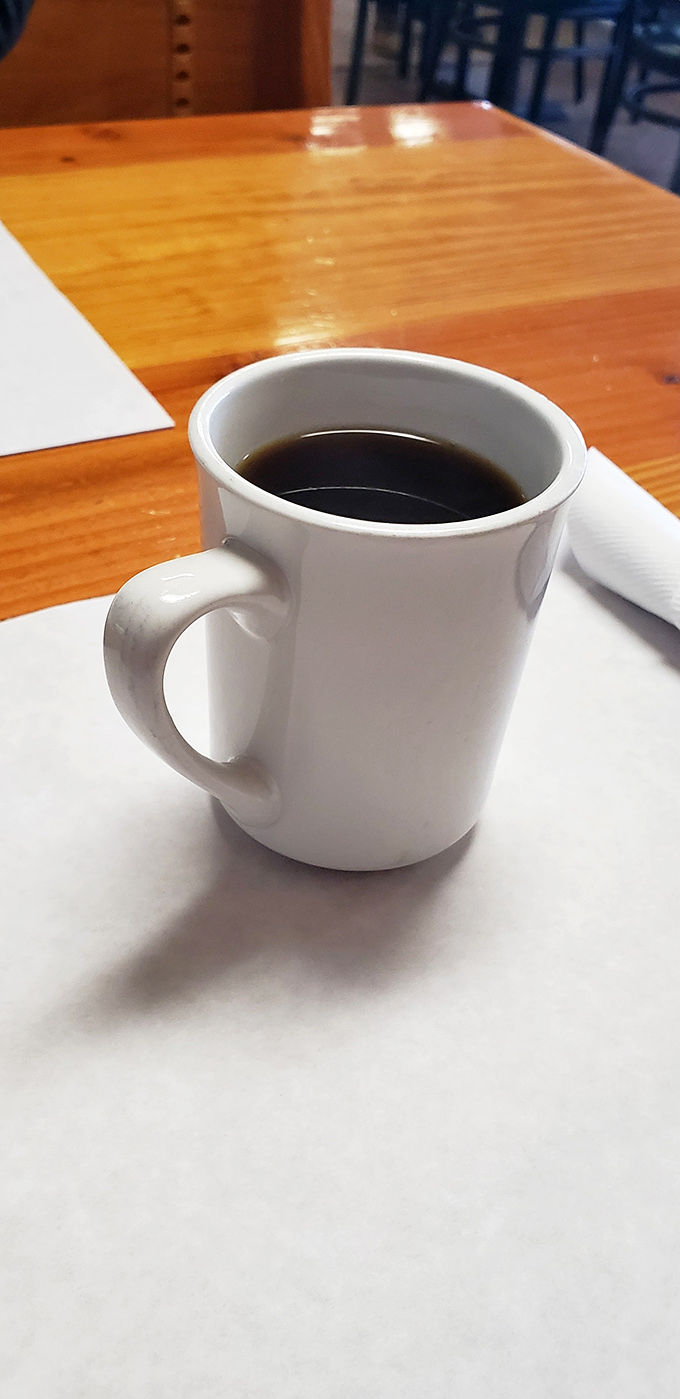 The humble white coffee mug – civilization's perfect delivery system for the caffeinated fuel that powers small-town America's morning conversations.