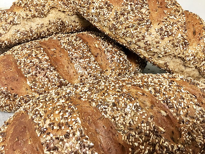 Whole grain loaves sprinkled with seeds like nature's confetti—your avocado toast has been waiting its whole life for this bread.