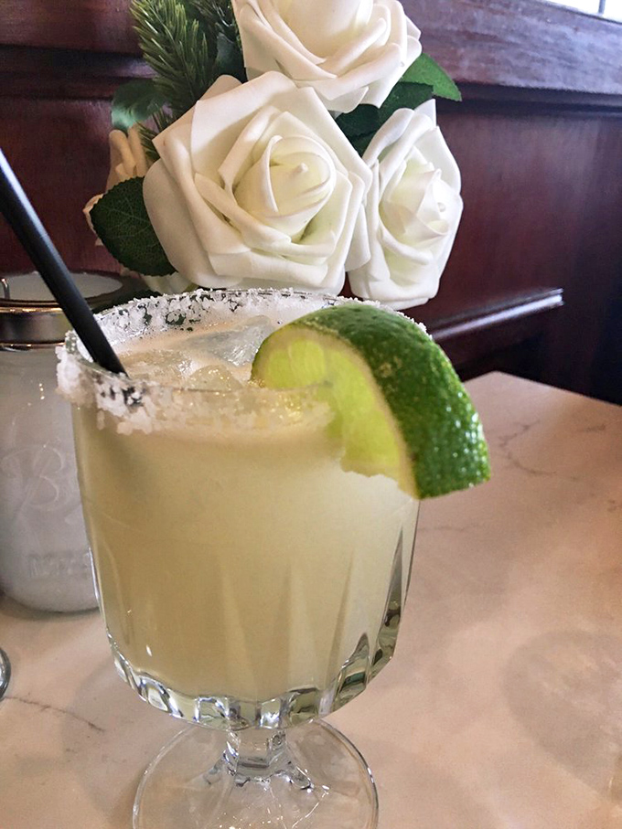 A margarita with a touch of class – salt-rimmed, lime-adorned, and served alongside elegant white roses. Cocktail hour never looked so sophisticated.