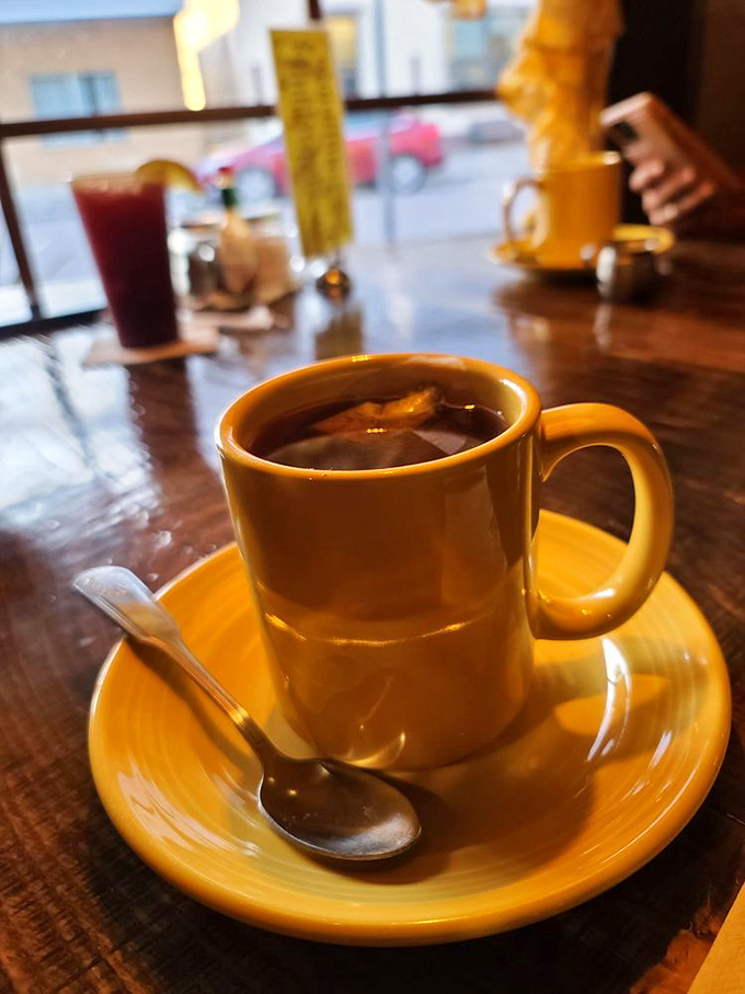 That golden ceramic mug doesn't just hold tea—it cradles liquid comfort on a wooden table that's seen decades of Tennessee stories.