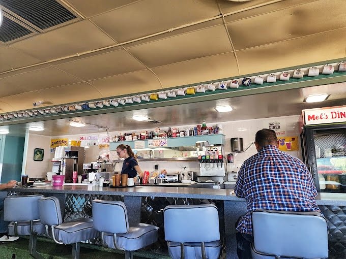 The counter at Mel's – where solo diners find community, regulars exchange neighborhood news, and the short-order ballet unfolds before your appreciative eyes.