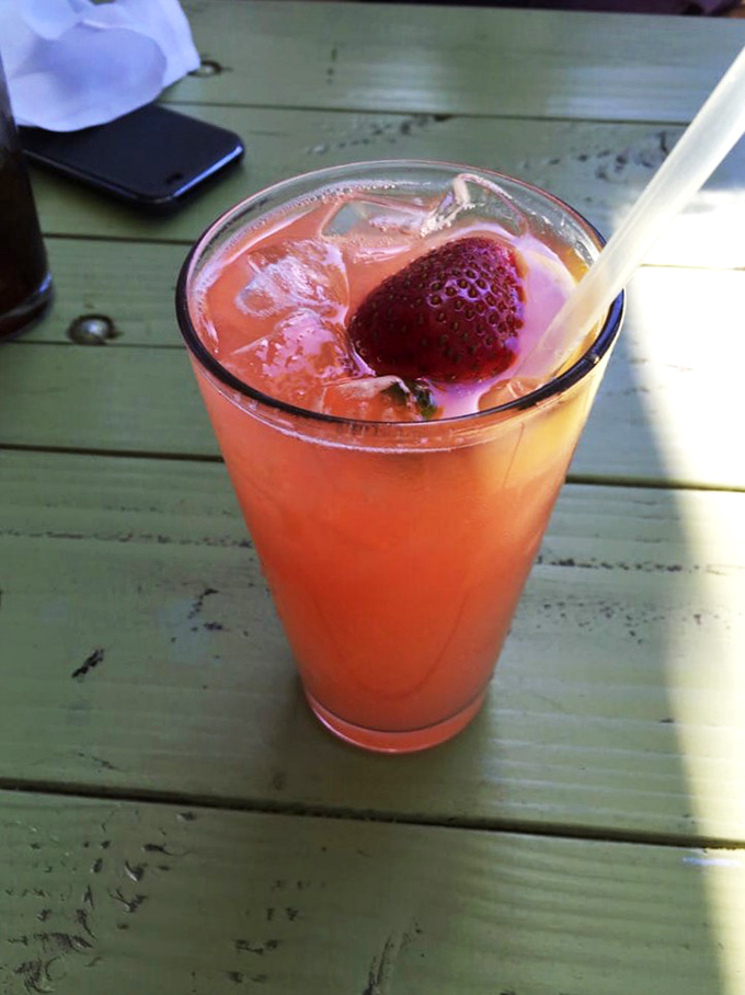 A strawberry lemonade that makes you wonder why anyone would ever choose soda. Sunshine in a glass, with that berry perched like a lifeguard watching over your refreshment.
