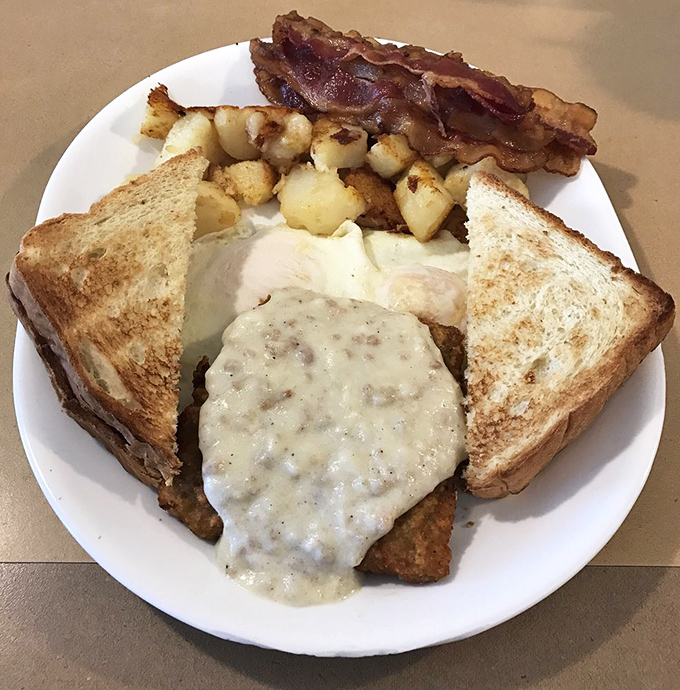 Country fried steak smothered in gravy—where crispy exterior meets tender interior in a dance of textures that never disappoints.
