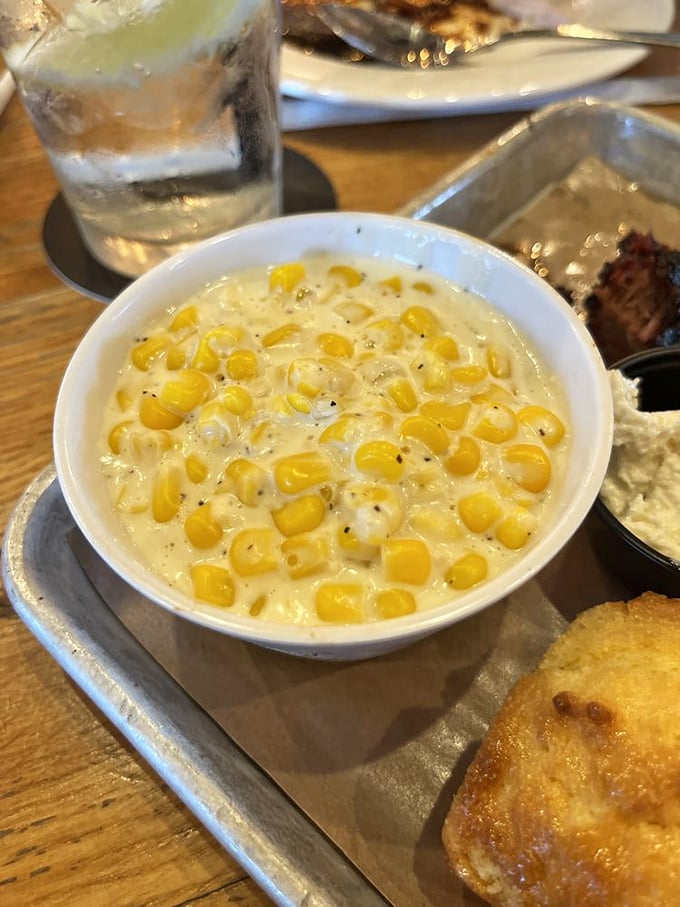 Creamed corn that makes you question why anyone would eat the canned stuff—sweet kernels swimming in a dairy pool of pure comfort.