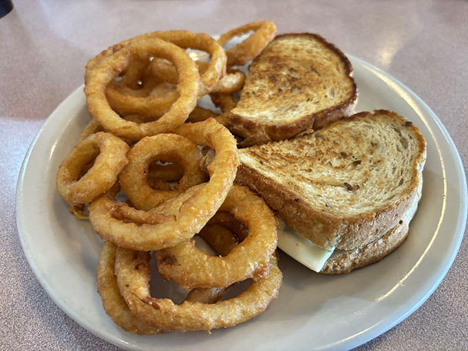 The onion rings and grilled sandwich combo – where crispy, melty, and savory meet for a conference on how to improve your day.