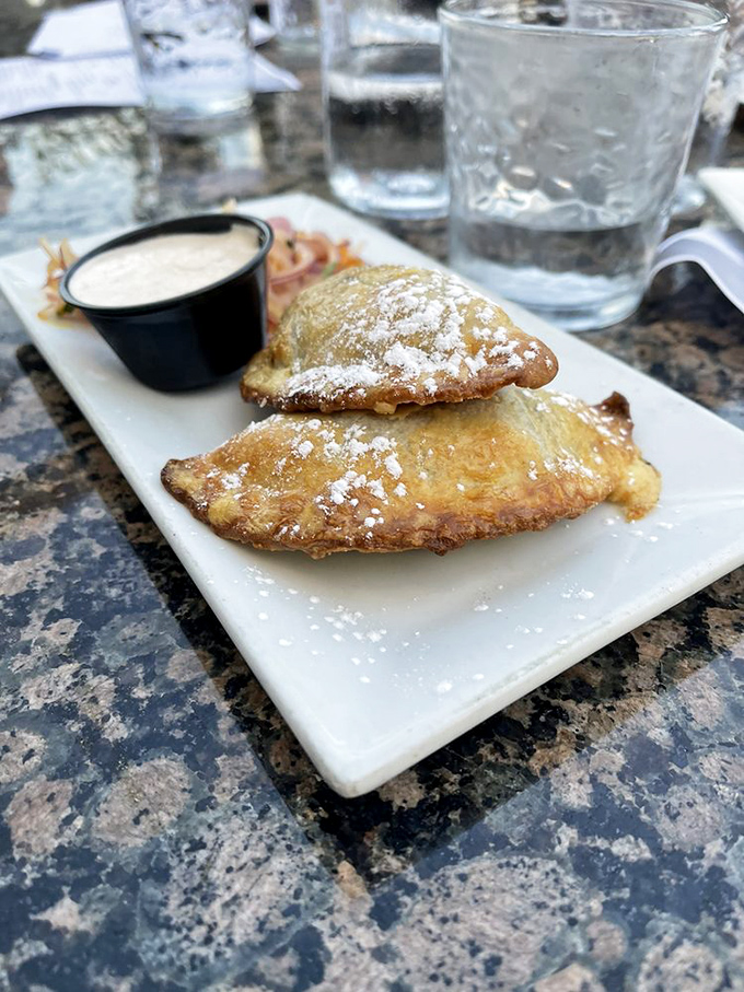 These golden-brown empanadas dusted with powdered sugar aren't just appetizers; they're little pockets of joy that make waiting for your entrée a pleasure, not a chore.