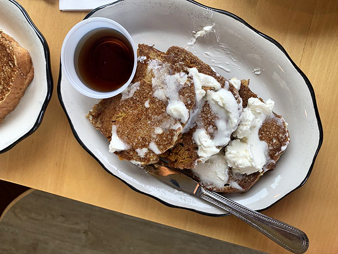 Pumpkin bread transformed into French toast with maple syrup and butter – autumn's greatest contribution to breakfast, available whenever you need comfort on a plate.