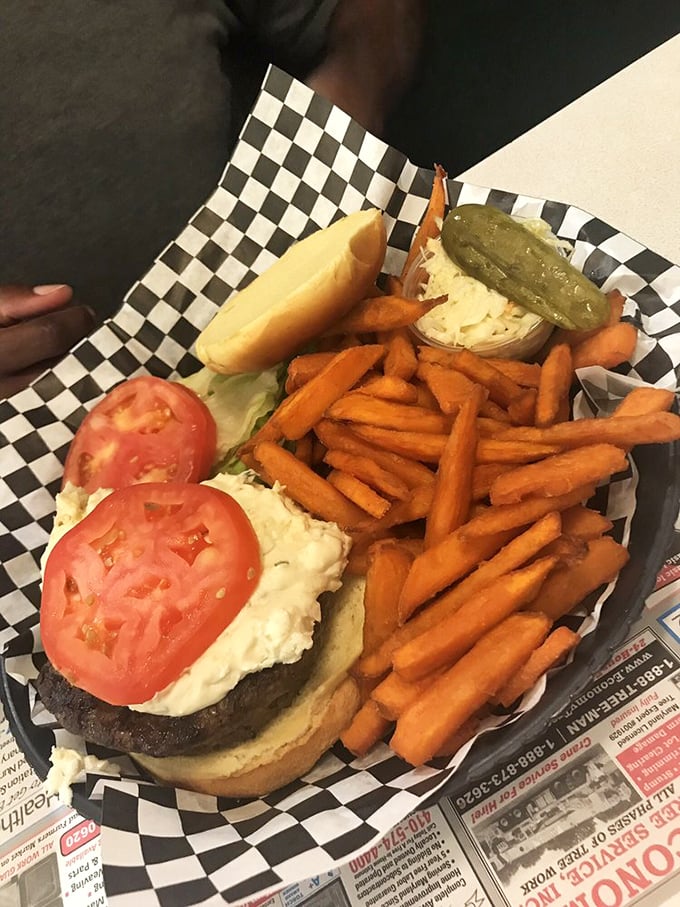 A burger that requires both hands and possibly a strategic plan of attack. Those sweet potato fries aren't just sides—they're supporting characters in this delicious drama.