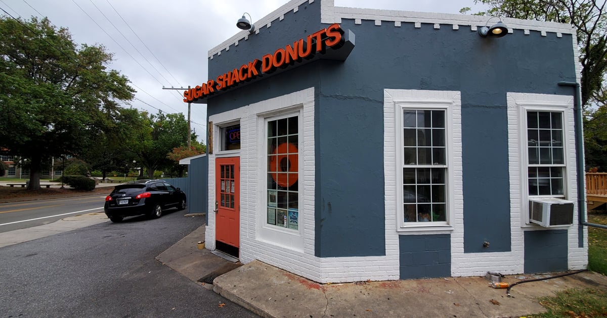 The blue-gray exterior with that coral door isn't just inviting—it's practically a siren song for your sweet tooth. Richmond's donut paradise awaits.