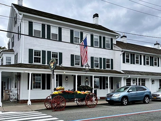 The white clapboard exterior of The Griswold Inn stands proudly in Essex, its patriotic bunting and antique wagon announcing: history happened here, and it was delicious.