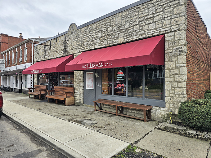The unassuming stone exterior with its crimson awning doesn't scream "burger legend," but the wooden benches outside hint at something worth waiting for.