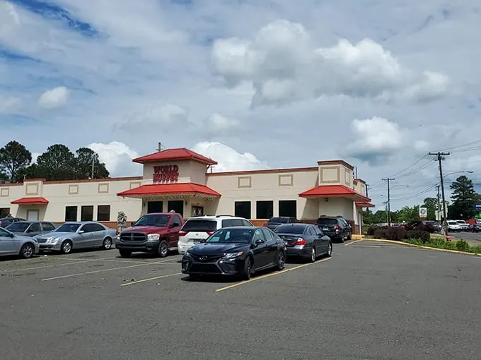 The iconic red-roofed entrance to World Buffet, where stone guardian lions stand sentinel, promising an epic feast within these hallowed walls.