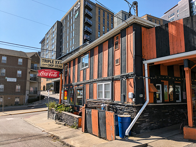The iconic orange and black striped exterior of Triple XXX stands like a time capsule on the hill, beckoning hungry travelers with its vintage Coca-Cola signage and timeless charm.