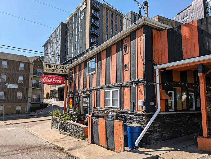The iconic orange and black striped exterior of Triple XXX stands like a time capsule on the hill, beckoning hungry travelers with its vintage Coca-Cola signage and timeless charm.