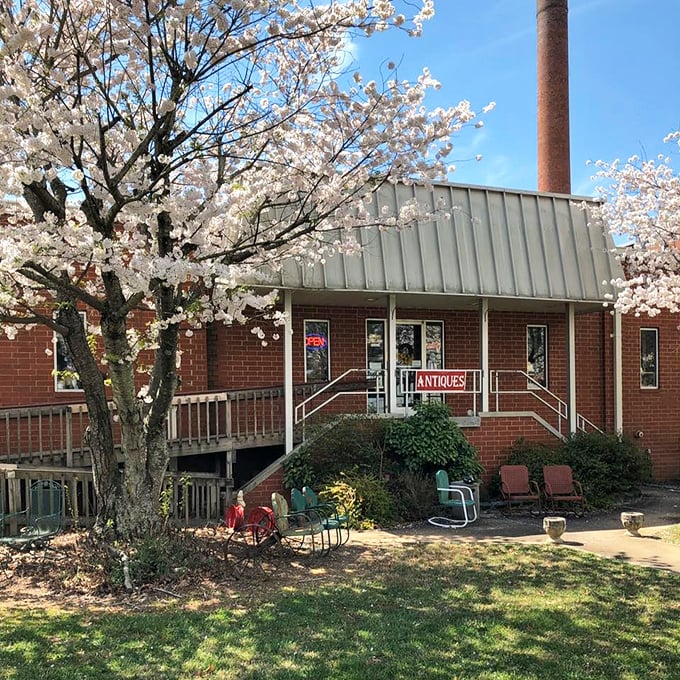 The unassuming brick façade with its vintage metal chairs and flamingo sentinel—proof that the best treasure maps often start with a simple "ANTIQUES" sign.