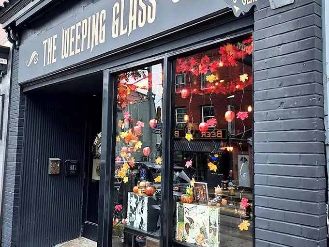 The Weeping Glass beckons curious passersby with gold lettering that promises "ODDITIES" and "CURIOSITIES" – an invitation few can resist.