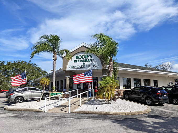 Sunshine, palm trees, and pancakes – Rodie's exterior promises Florida charm with its welcoming entrance and twin American flags fluttering in the Gulf breeze.