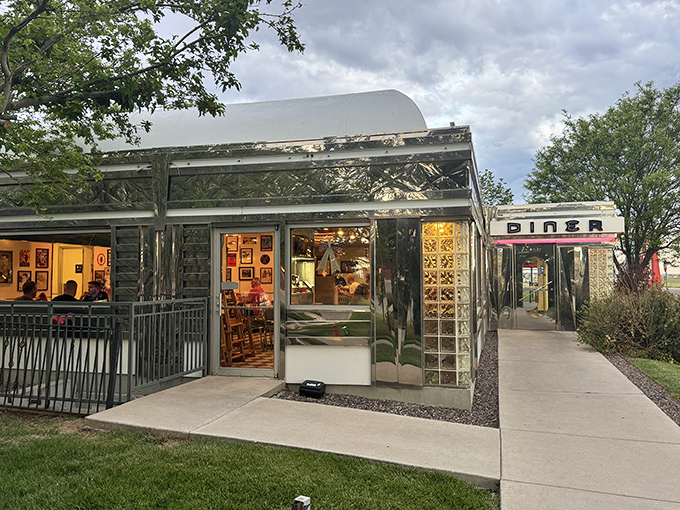 That neon sign doesn't whisper—it announces with retro swagger: "Hungry humans, your comfort food paradise awaits!" The turquoise and red color scheme practically sings against the Colorado sky.