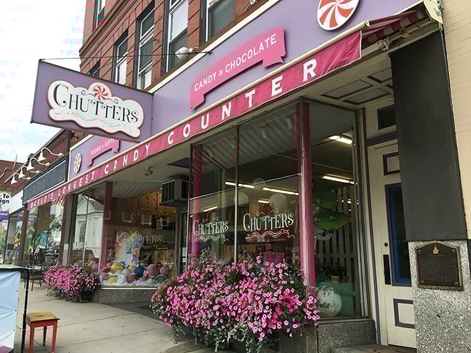 The iconic pink storefront of Chutters beckons like a sugary mirage on Littleton's Main Street. Those purple flowers aren't just decoration—they're a warning sign that willpower goes to die here.