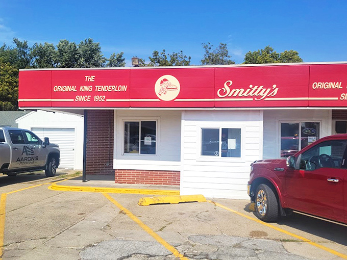 The bright red awning of Smitty's proudly announces "The Original King Tenderloin Since 1952"—a culinary landmark that's been perfecting pork longer than most of us have been eating it.