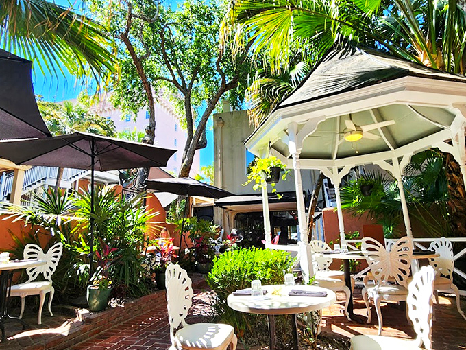 The courtyard at 82 Queen feels like Charleston's best-kept secret—a lush oasis where palm fronds and wrought-iron chairs conspire to make time slow down deliciously.