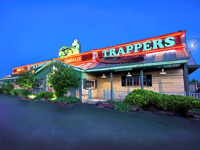 The rustic wooden facade of Trapper's beckons like an old friend, promising comfort food with Cajun flair beneath those neon signs.