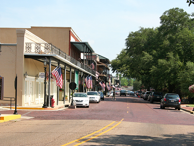 Front Street's historic charm on full display, where brick-paved streets and wrought-iron balconies create Louisiana's most walkable small-town downtown. 