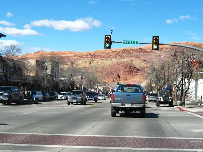 Main Street Moab, where pickup trucks are the fashion statement and those red rock backdrops aren't painted—Mother Nature just showing off.