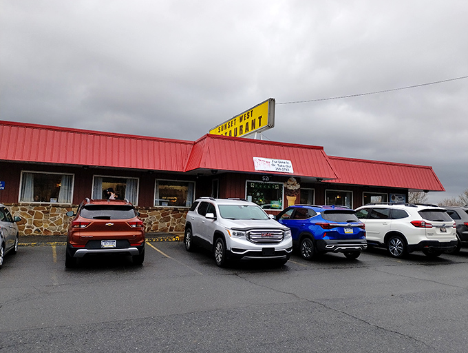 The iconic red roof and stone facade of Sunset West Restaurant stands as a beacon of comfort food in Pleasant Gap, where hungry travelers find their breakfast destiny.