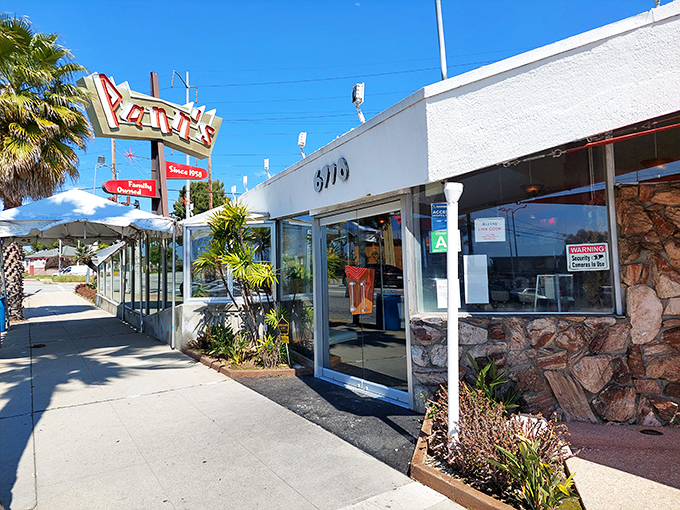 That iconic angular roof isn't just showing off—it's practically waving you in from the highway, promising comfort food beneath its Googie glory.
