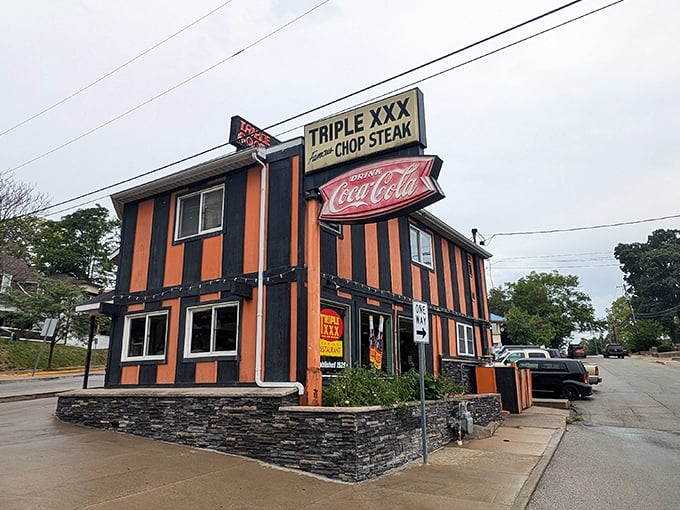 The iconic orange and black striped exterior of Triple XXX stands like a time capsule on the hill, beckoning hungry travelers with its vintage Coca-Cola signage and timeless charm.