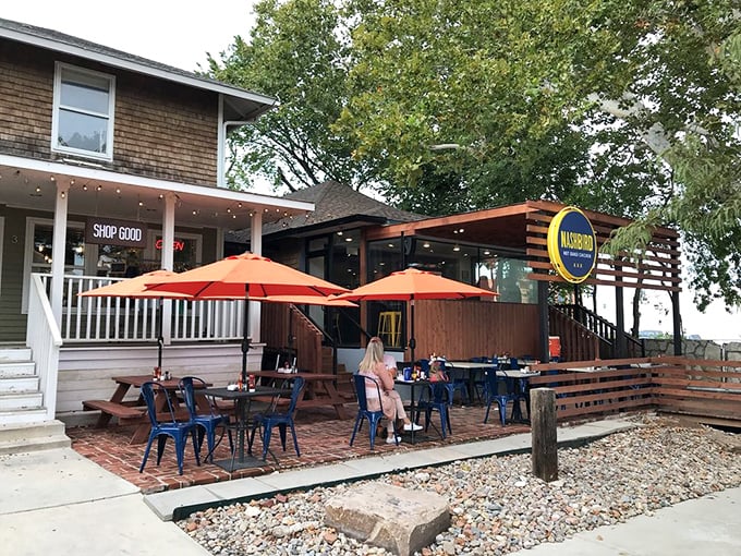 NASHBIRD's charming converted house exterior beckons with its wooden deck and bright signage—like a Southern porch that happens to serve life-changing chicken.