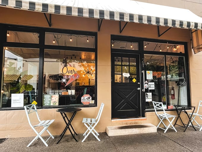 The storefront beckons with its simple charm—black door, striped awning, and outdoor seating that whispers, "Come in, the eggs are waiting." 