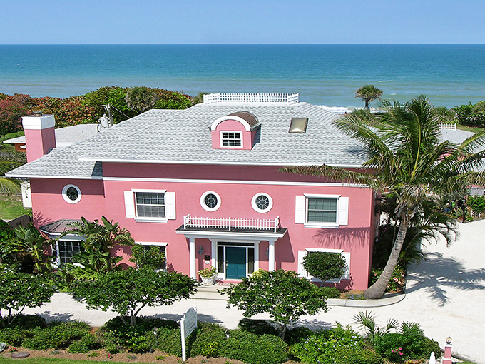 The coral-pink façade of Windermere Inn by the Sea stands like a blushing debutante against Florida's blue sky, promising coastal comfort with every white-trimmed window.