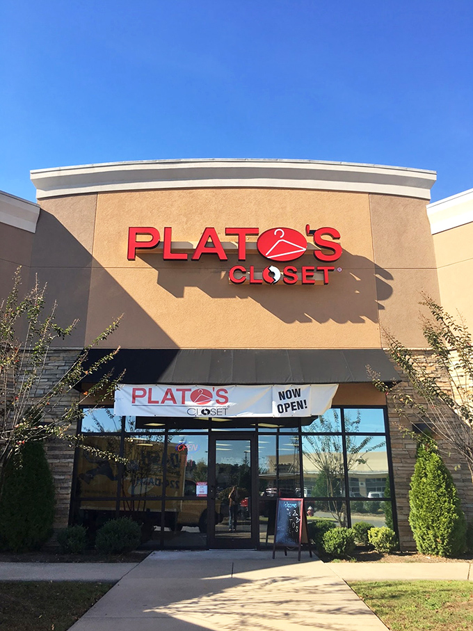 The tan façade and bold red signage of Plato's Closet beckons like a fashion oasis in the suburban retail landscape.