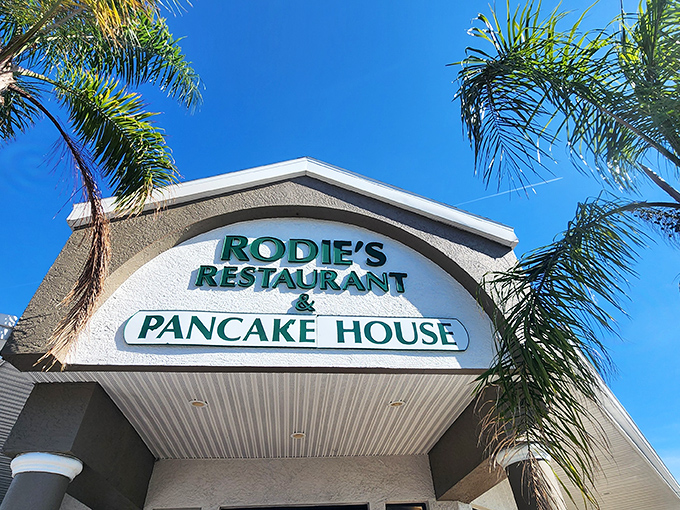 Sunshine, palm trees, and pancakes – Rodie's exterior promises Florida charm with its welcoming entrance and twin American flags fluttering in the Gulf breeze.