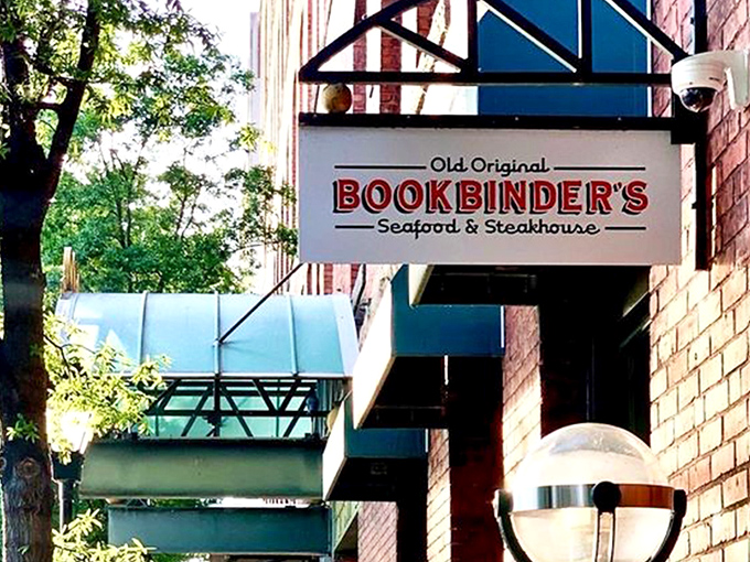 The historic brick façade of Bookbinder's welcomes you with teal awnings and warm globe lights—Richmond's culinary time machine disguised as a restaurant. 