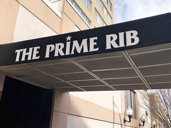The understated elegance of The Prime Rib's entrance promises what lies beyond—a Baltimore dining institution where time stands deliciously still.