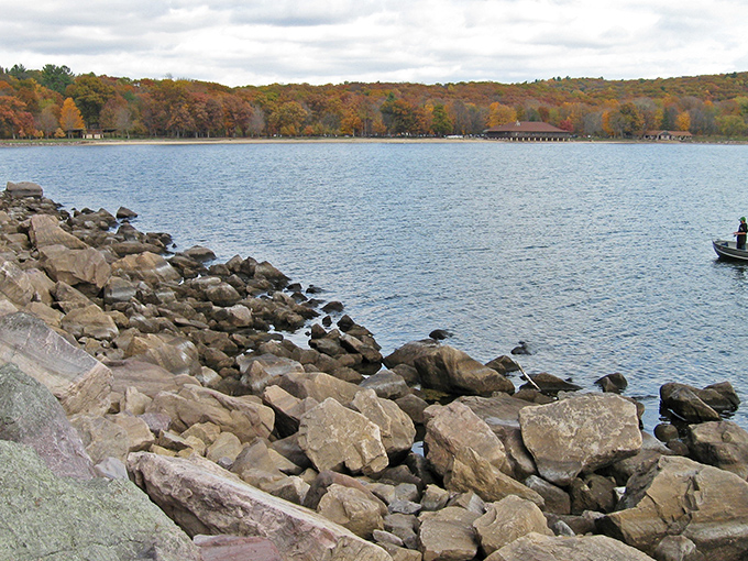 The shoreline tells ancient stories in stone. Devil's Lake's crystal waters meet million-year-old quartzite in nature's perfect handshake.