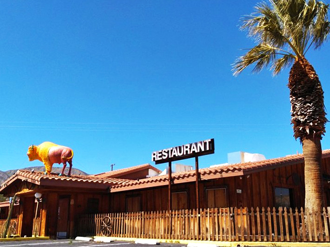 The giant yellow and pink buffalo on the roof isn't a desert mirage—it's your signal that pasta paradise awaits at Spaghetti Western in Morongo Valley.