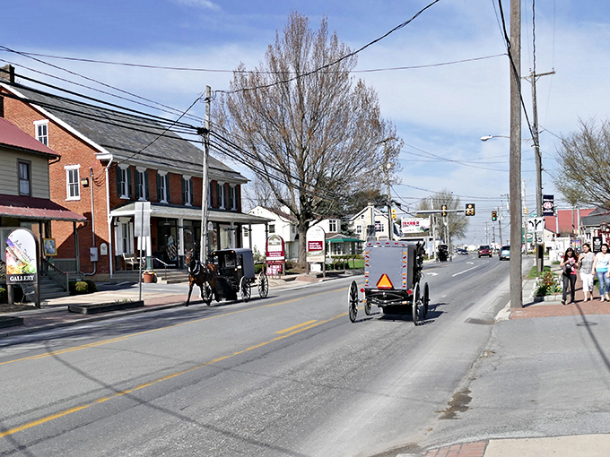 Where horse-drawn buggies and modern vehicles share the road in perfect harmony. A typical scene in Intercourse, where time moves at its own gentle pace.