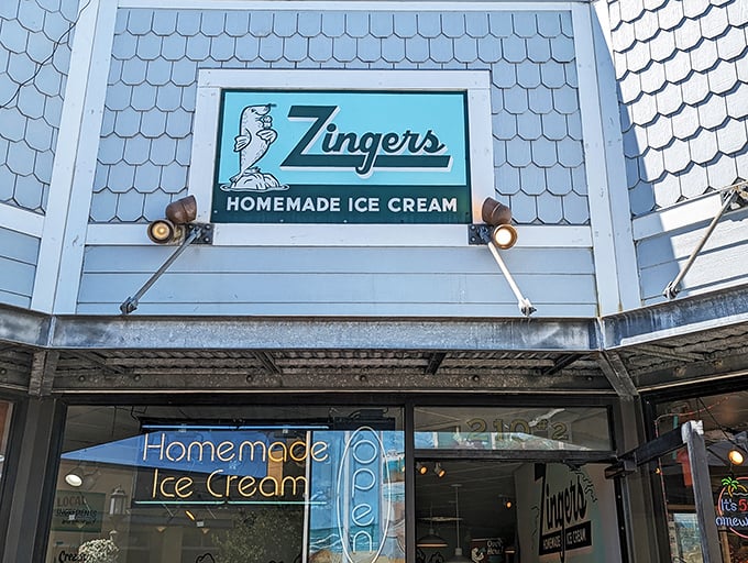 The iconic blue-shingled exterior of Zingers stands like a beacon of sweet promises on Seaside's Broadway Street, complete with their playful sea lion mascot. 
