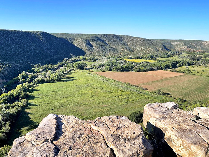 Nature's grand theater unfolds at Villanueva, where sandstone cliffs stand like ancient sentinels guarding the verdant valley below. 