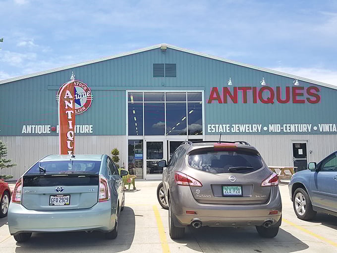 The mint-green exterior of Saugatuck Antique Pavilion stands proudly against a blue Michigan sky, with a classic convertible parked out front—nostalgia in architectural and automotive form.