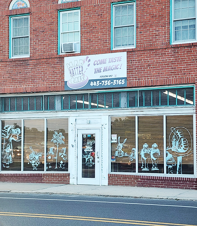 The brick facade of Mad Hatter Cafe beckons with whimsical window art—Lewis Carroll's fantasy brought to life on Salisbury's Main Street.