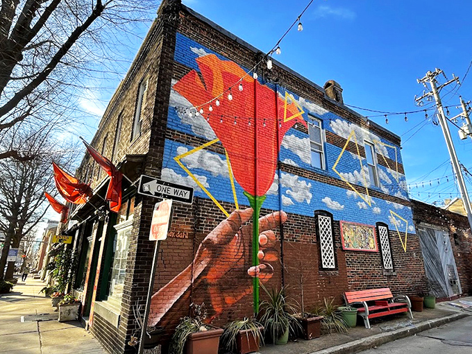 The exterior mural transforms this brick building into a vibrant landmark. Who needs subtle signage when you can have a giant hand holding a flower against the sky?