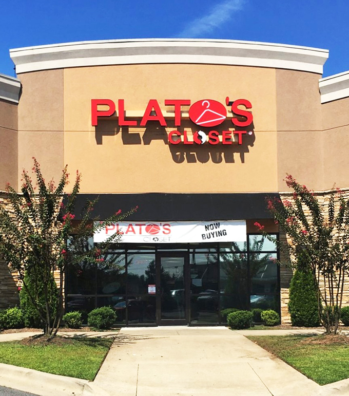 The tan façade and bold red signage of Plato's Closet beckons like a fashion oasis in the suburban retail landscape.