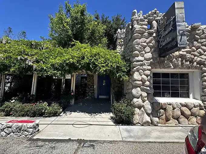 Stone by stone, this fairy tale façade promises culinary magic within. The blue door isn't just an entrance—it's a portal to France itself.