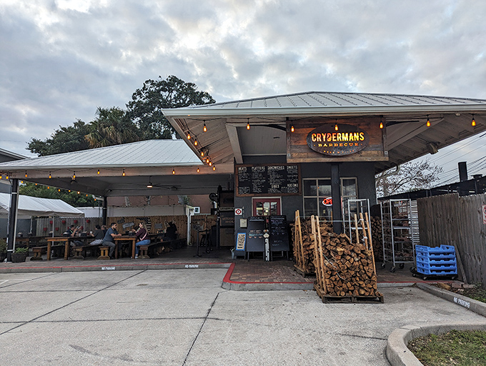 The unassuming exterior of Crydermans hides barbecue greatness like a superhero's secret identity. Stacked firewood isn't decor—it's a promise of smoky deliciousness to come.