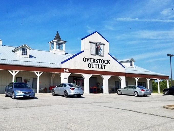 The unassuming barn-style exterior of Overstock Outlet promises treasure within—like finding a secret gold mine disguised as a humble homestead.